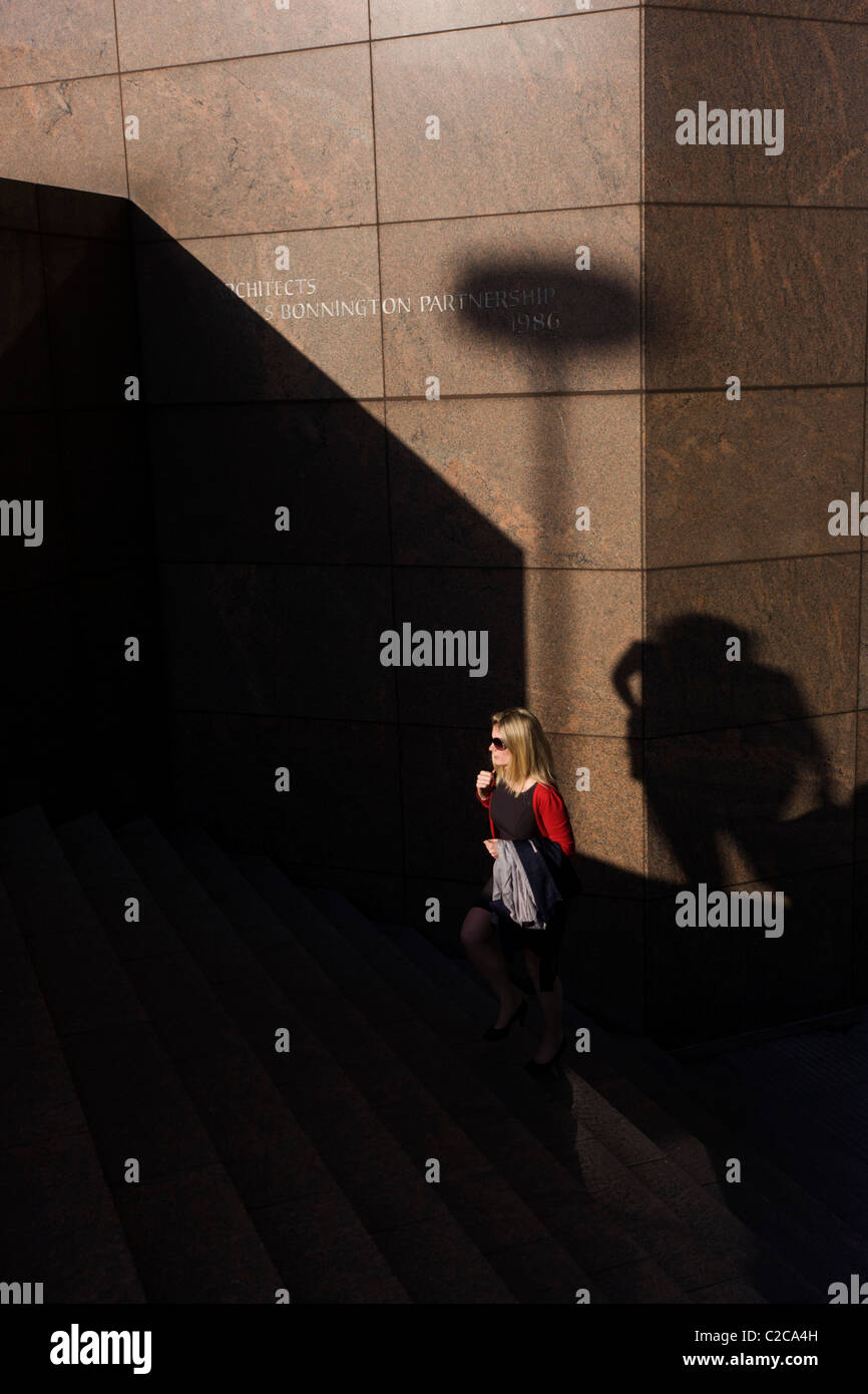 Surrounded by deep shadows, a commuter climbs the steps of number 1 ...