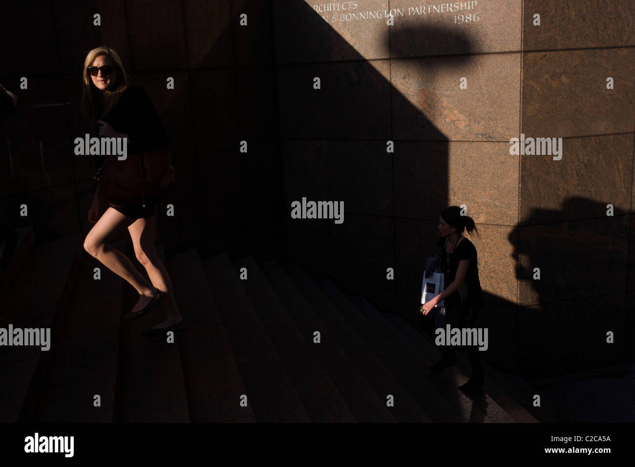 Surrounded by deep shadows, commuters climb the steps of number 1 ...