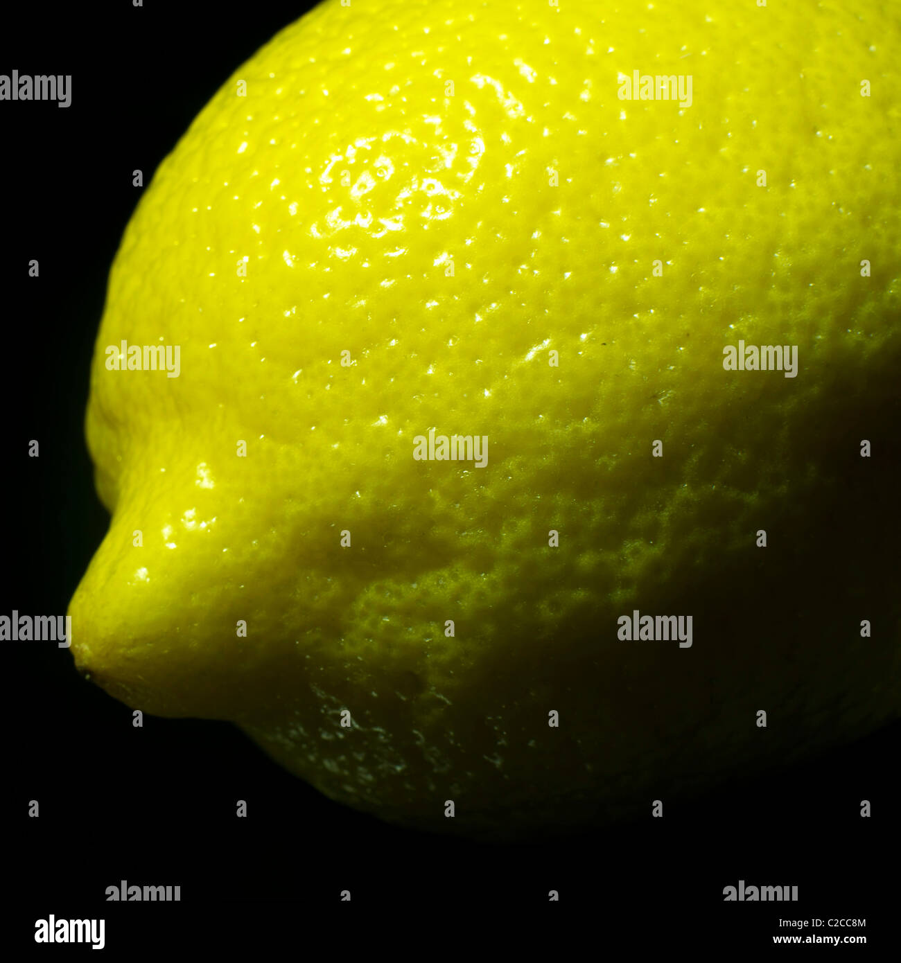 A close up of a single lemon on a black back ground Stock Photo - Alamy
