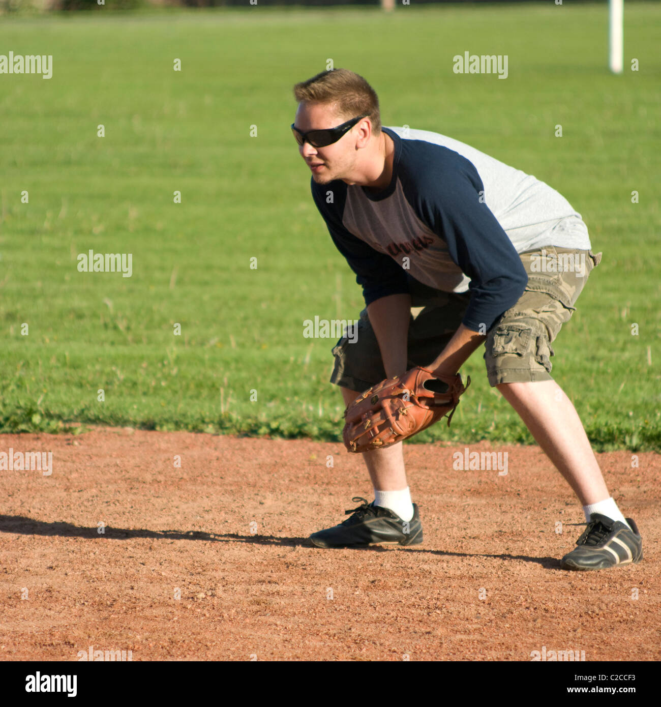 A young man playing baseball in the infield waits for the hit Stock ...