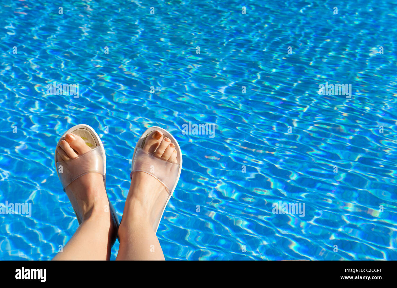 Feet in beach slippers on the brink of pool Stock Photo - Alamy