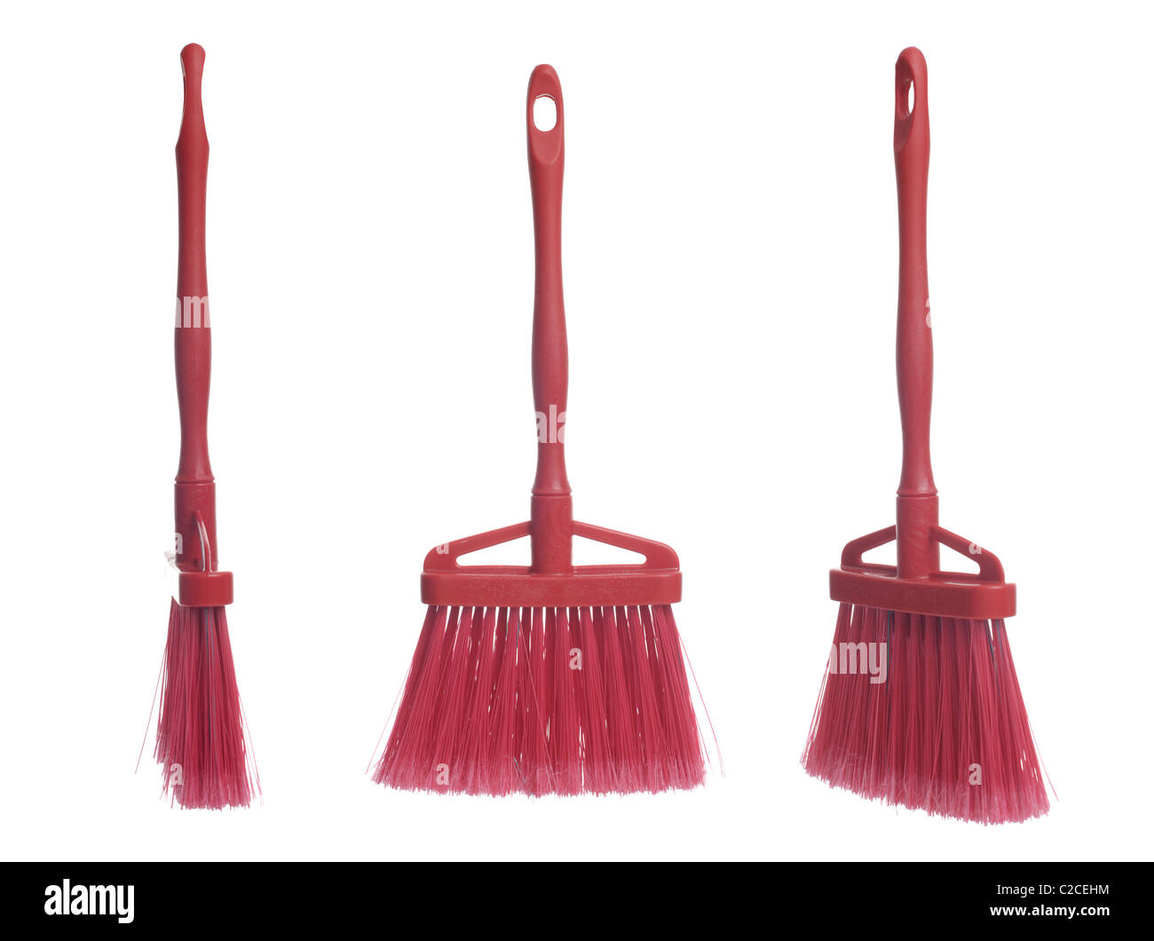 Three plastic red brooms isolated on white background Stock Photo - Alamy