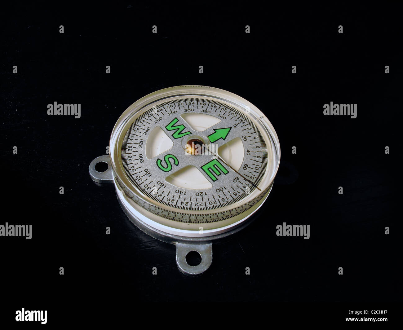 Small compass on a black background Stock Photo - Alamy