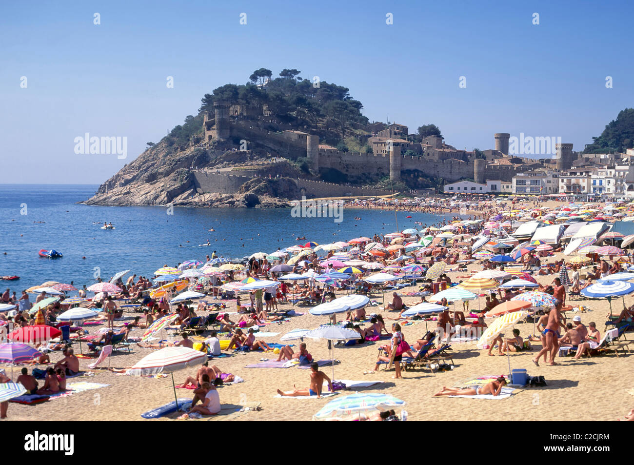 Crowd of people sunbathing on busy sand seaside holiday family beach ...