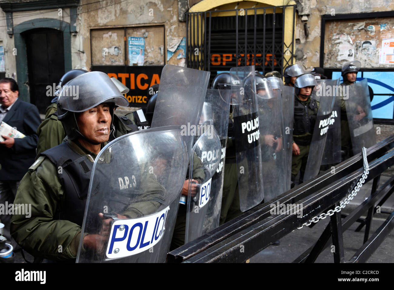 Riot police standing behind security barrier to restrict access to ...