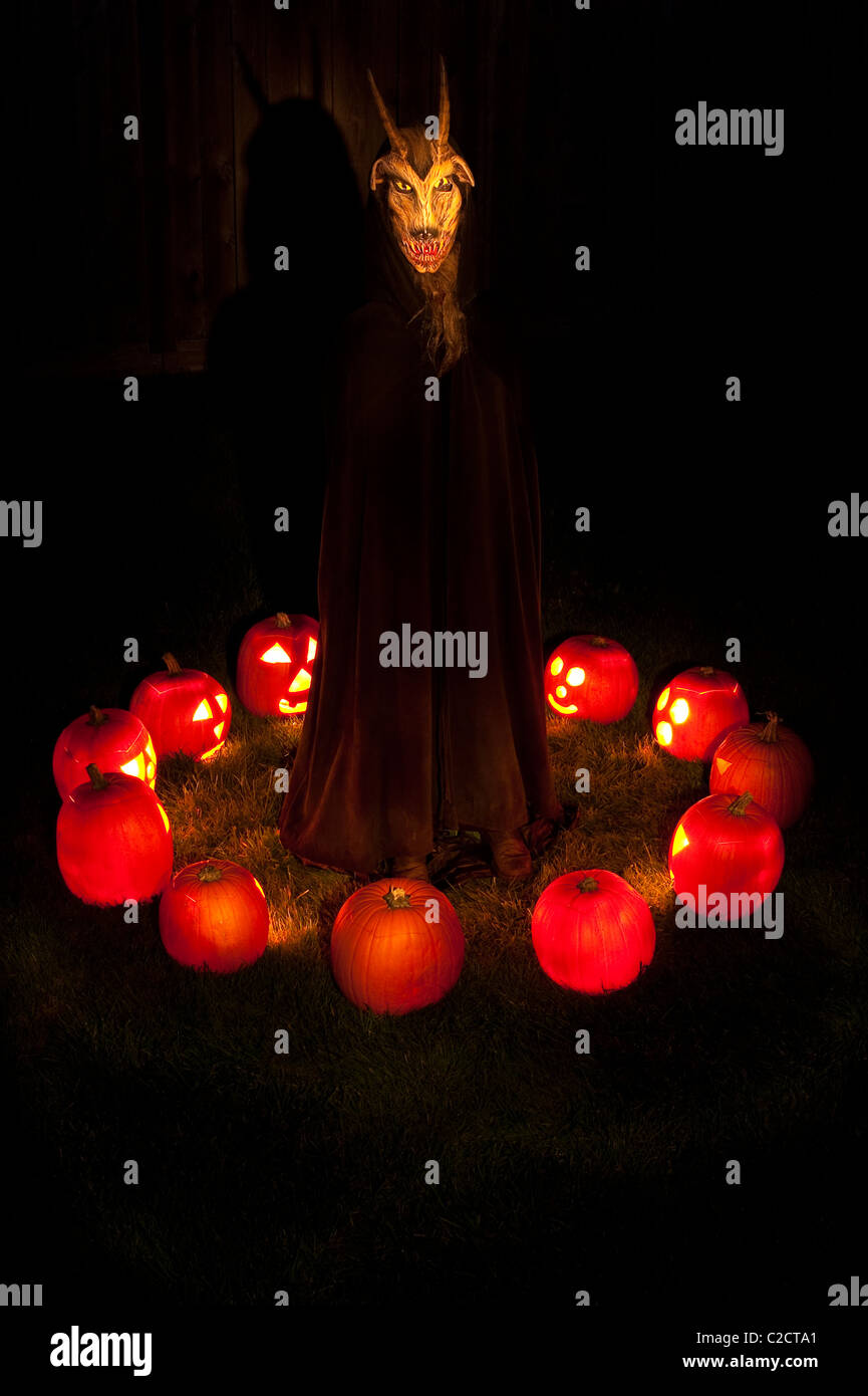 Scary lit carved pumpkins at twilight all looking at Demon Goat with ...