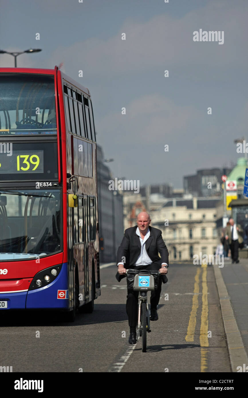 A male cyclist cycling on a Boris Bike in London, England with a bus passing Stock Photo - Alamy