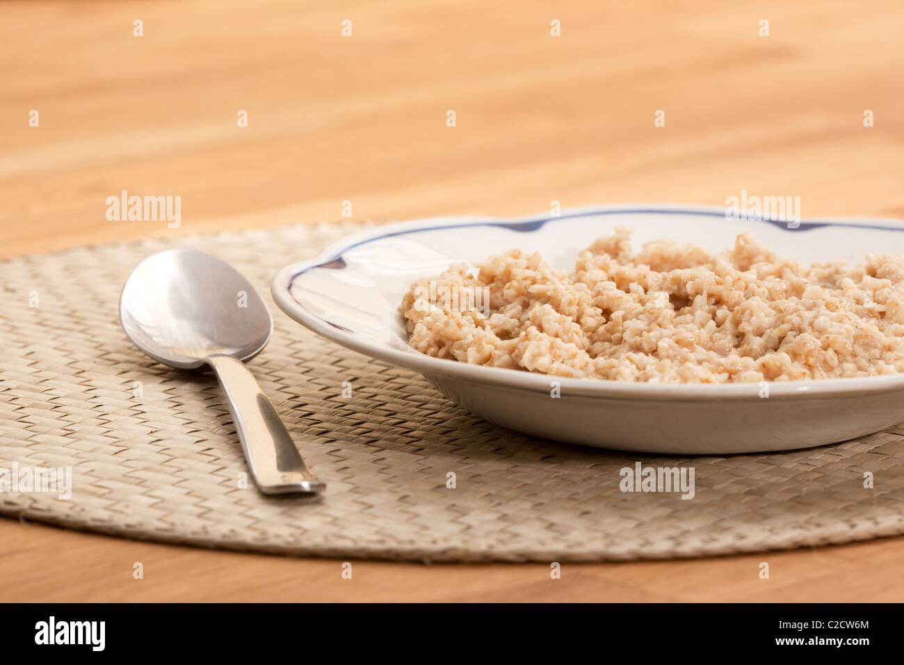 A bowl of porridge on a table with a spoon Stock Photo - Alamy