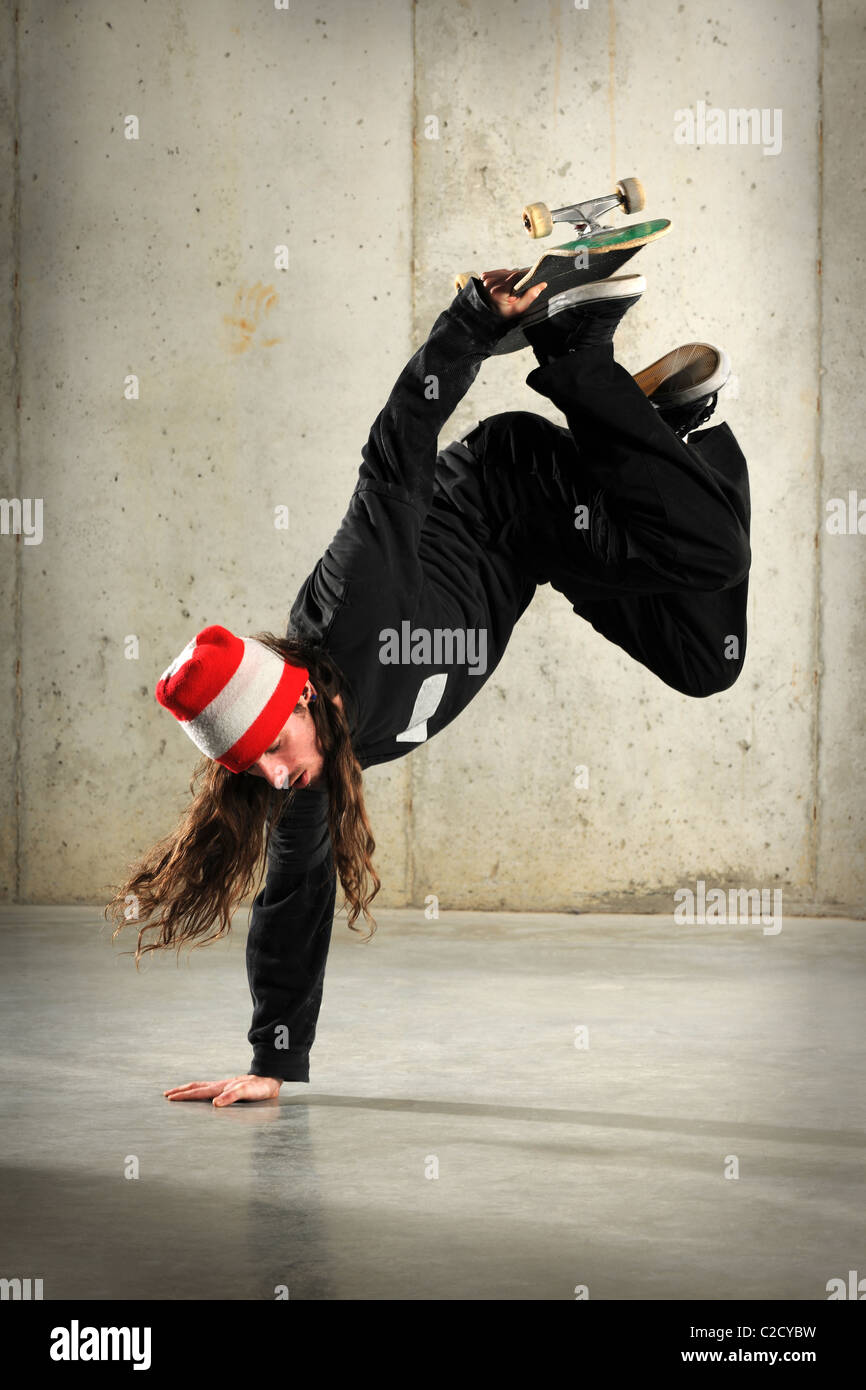 Young man with skateboard performing handstand trick Stock Photo - Alamy