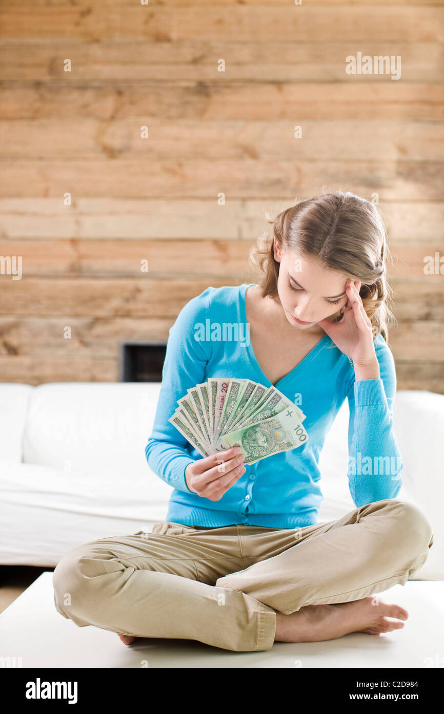 Woman looking at money Stock Photo - Alamy