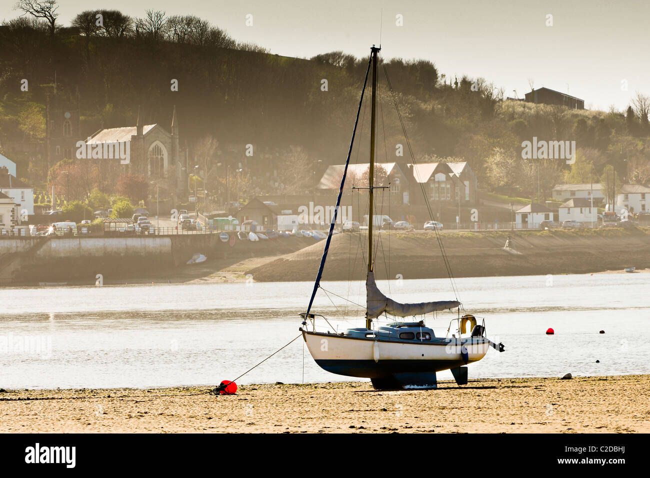 A sailing yacht at low tide with the village of Appledore in the ...