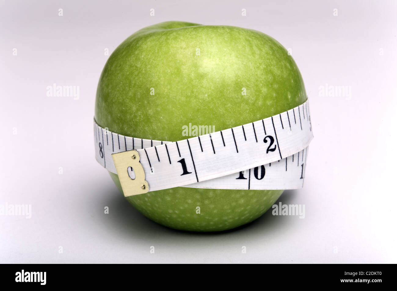 Measuring tape around an apple representing slimming and a healthy diet ...