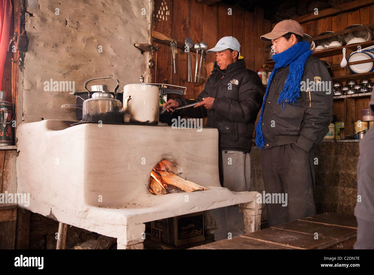 Two men cooking with a traditional old clay Nepali Kitchen. Langtang ...