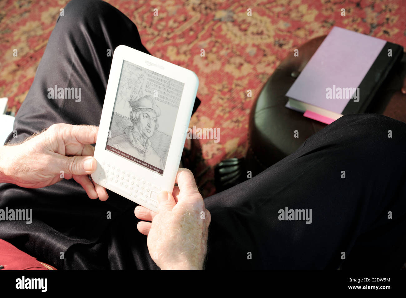 Subject reading e-book displayed on Kindle reader Stock Photo - Alamy