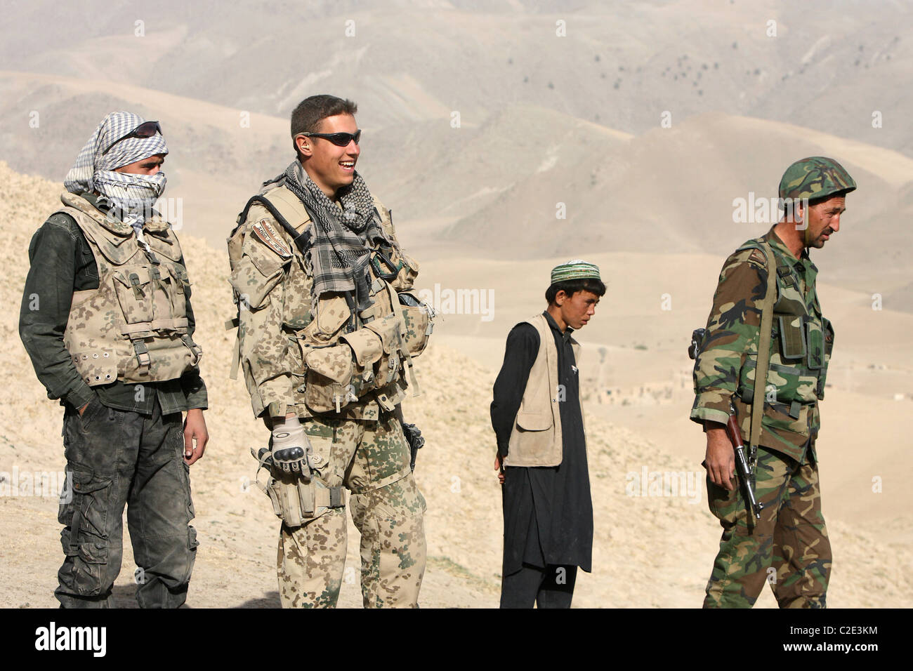 An ISAF soldier and an Afghan soldier on patrol, Feyzabad, Afghanistan ...