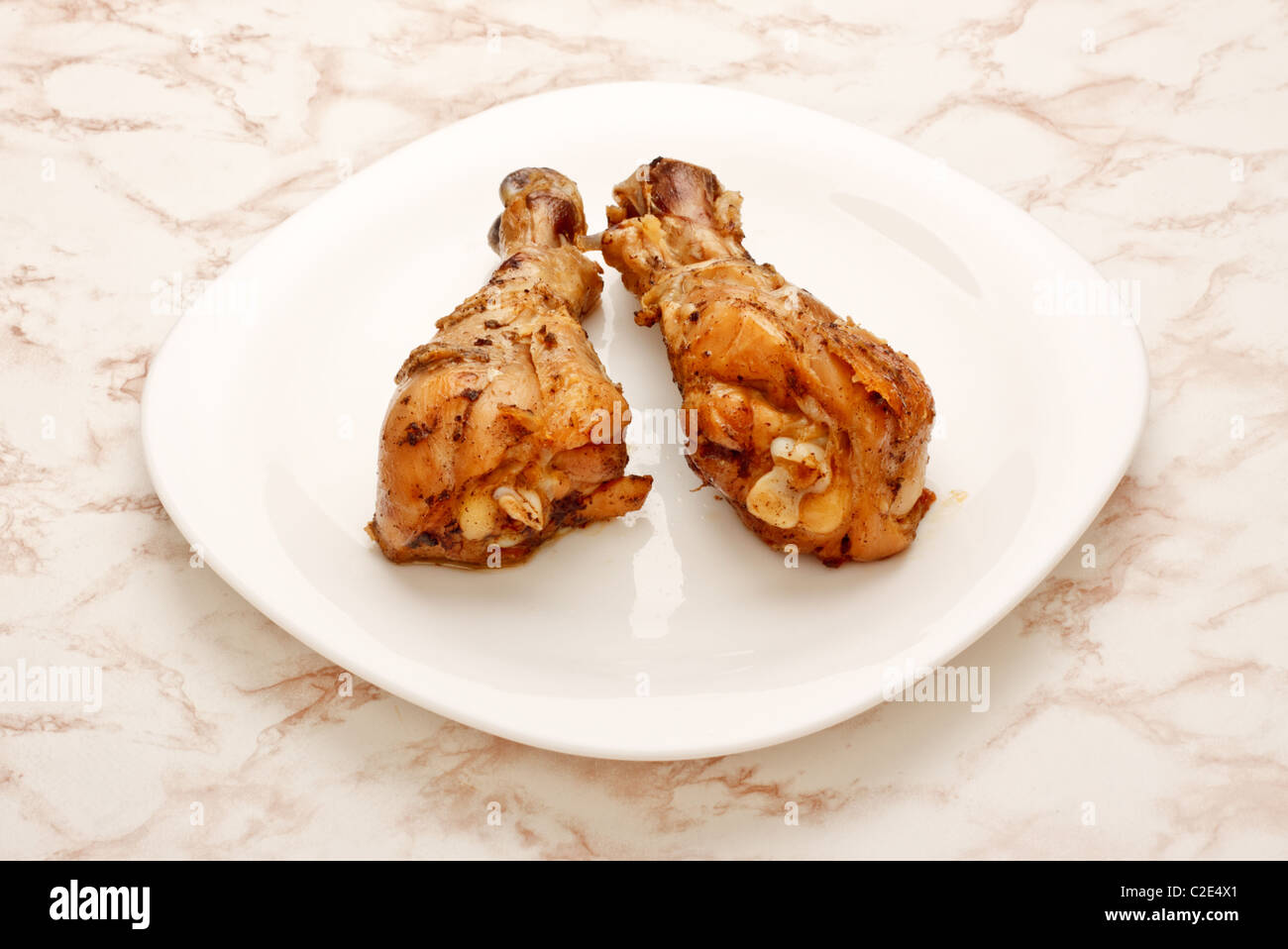 two crispy fried chicken legs on a white dish Stock Photo - Alamy