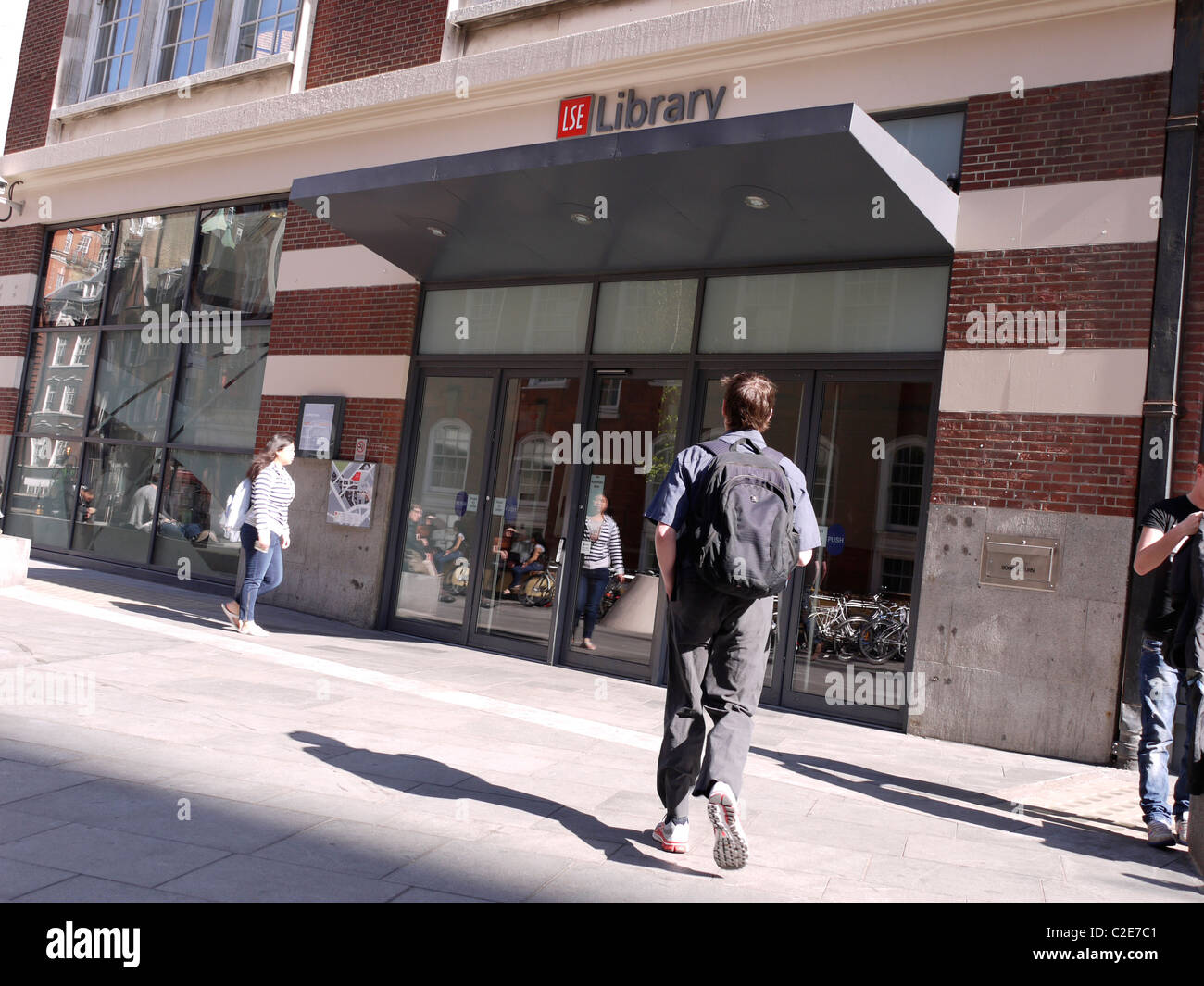 Pedestrians walk into LSE Library, London – a hub of knowledge at the heart of the London School ...