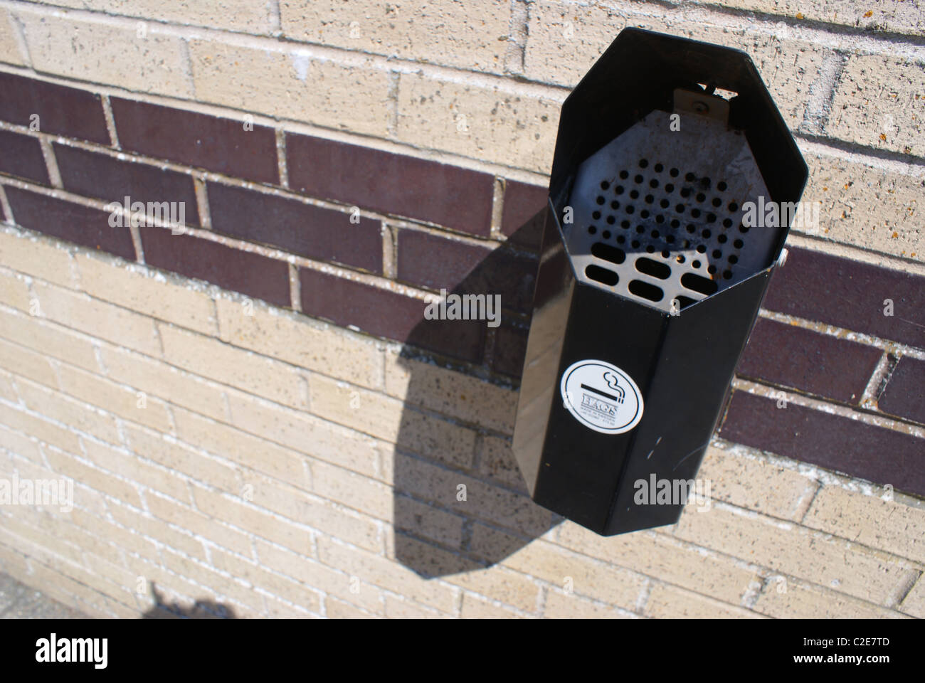Cigarette bin on brick wall Stock Photo - Alamy