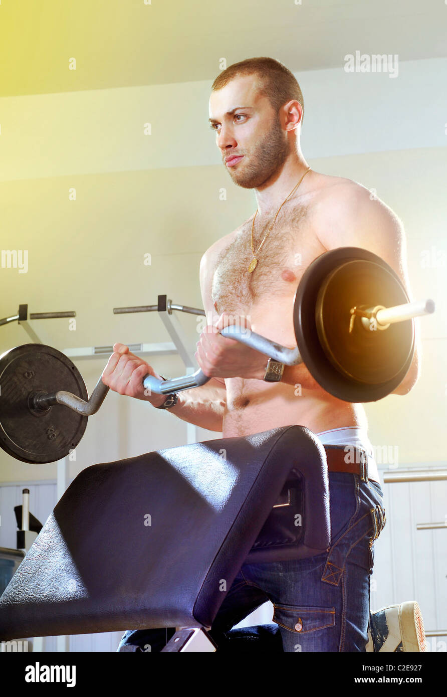man makes exercises with bar in exercise room Stock Photo - Alamy