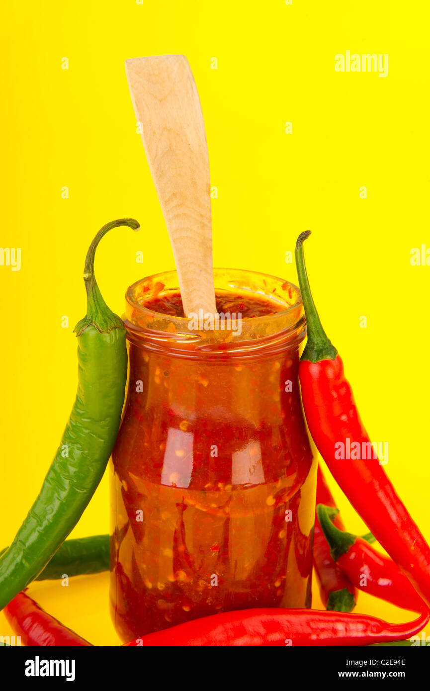 Fresh red hot chili peppers and glass pot of paste Stock Photo - Alamy