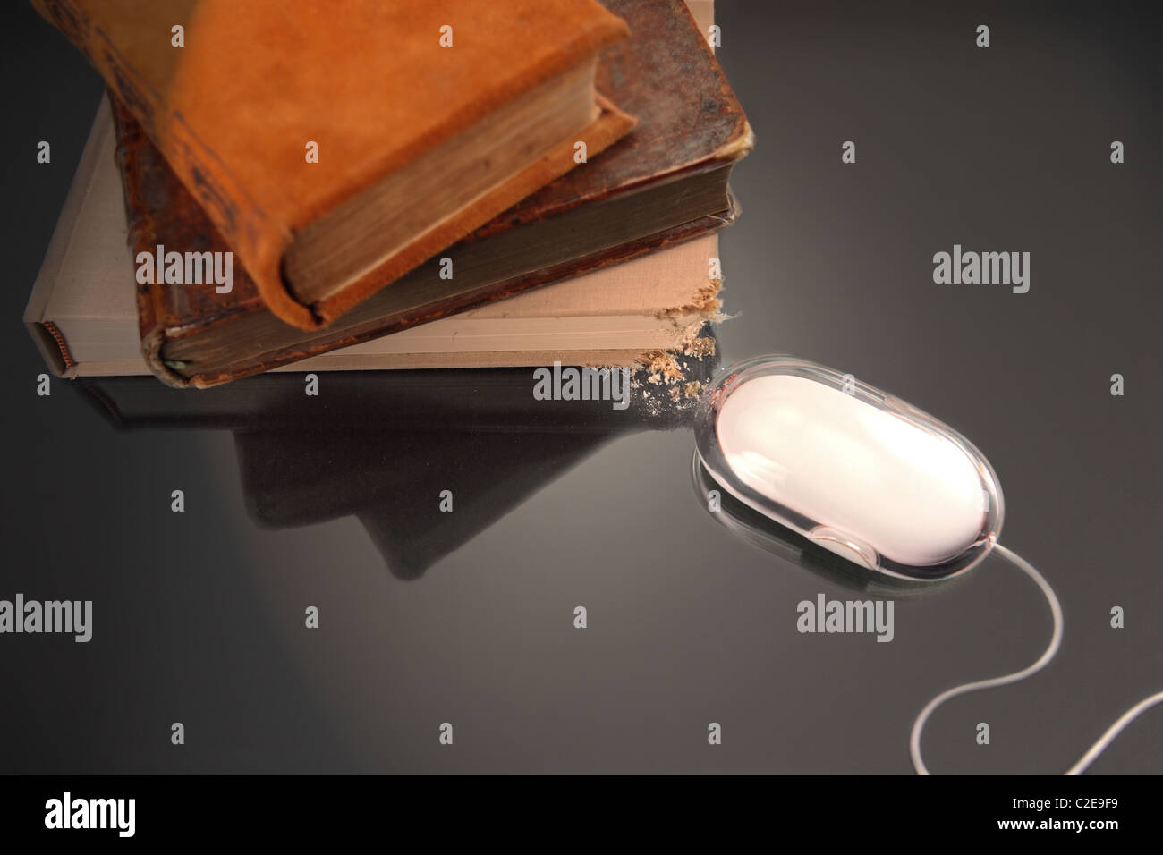 A computer mouse who gnaws ancient books on a glass table Stock Photo ...
