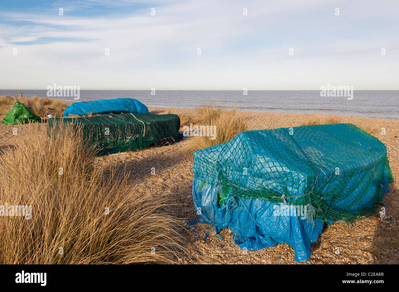 Boats covered up on the beach at Kessingland , Suffolk , England ...