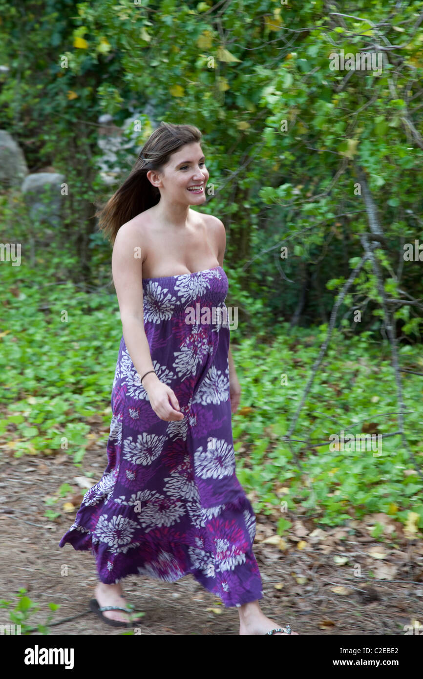 Lovely woman strolling down a path beside some trees Stock Photo - Alamy