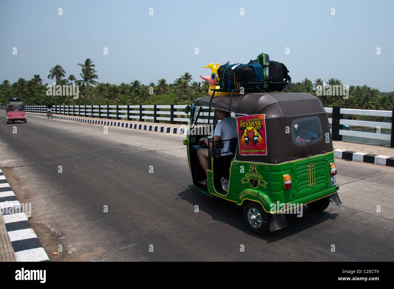 Pimped up tuk tuks travel over bridge in Kerala in the Rickshaw Run ...