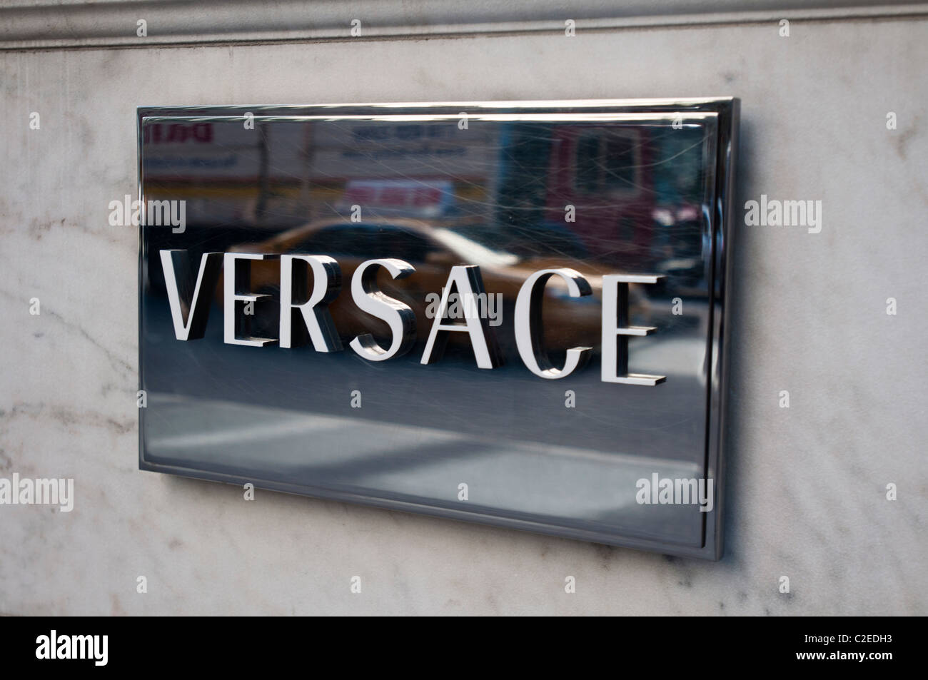 Metal Versace store plaque on 5th Avenue with yellow cab reflection ...