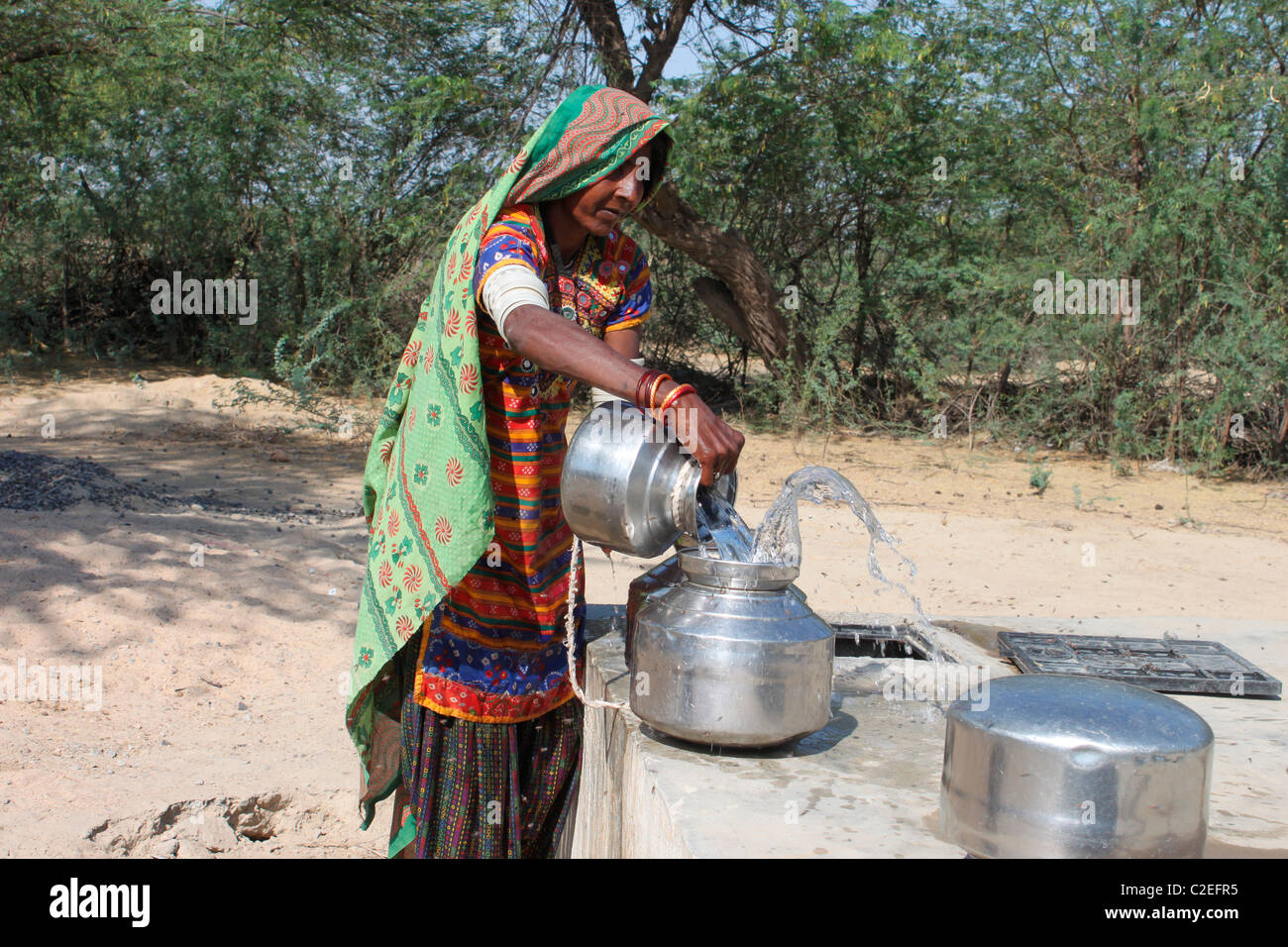 A rural woman collecting water from a well Stock Photo - Alamy