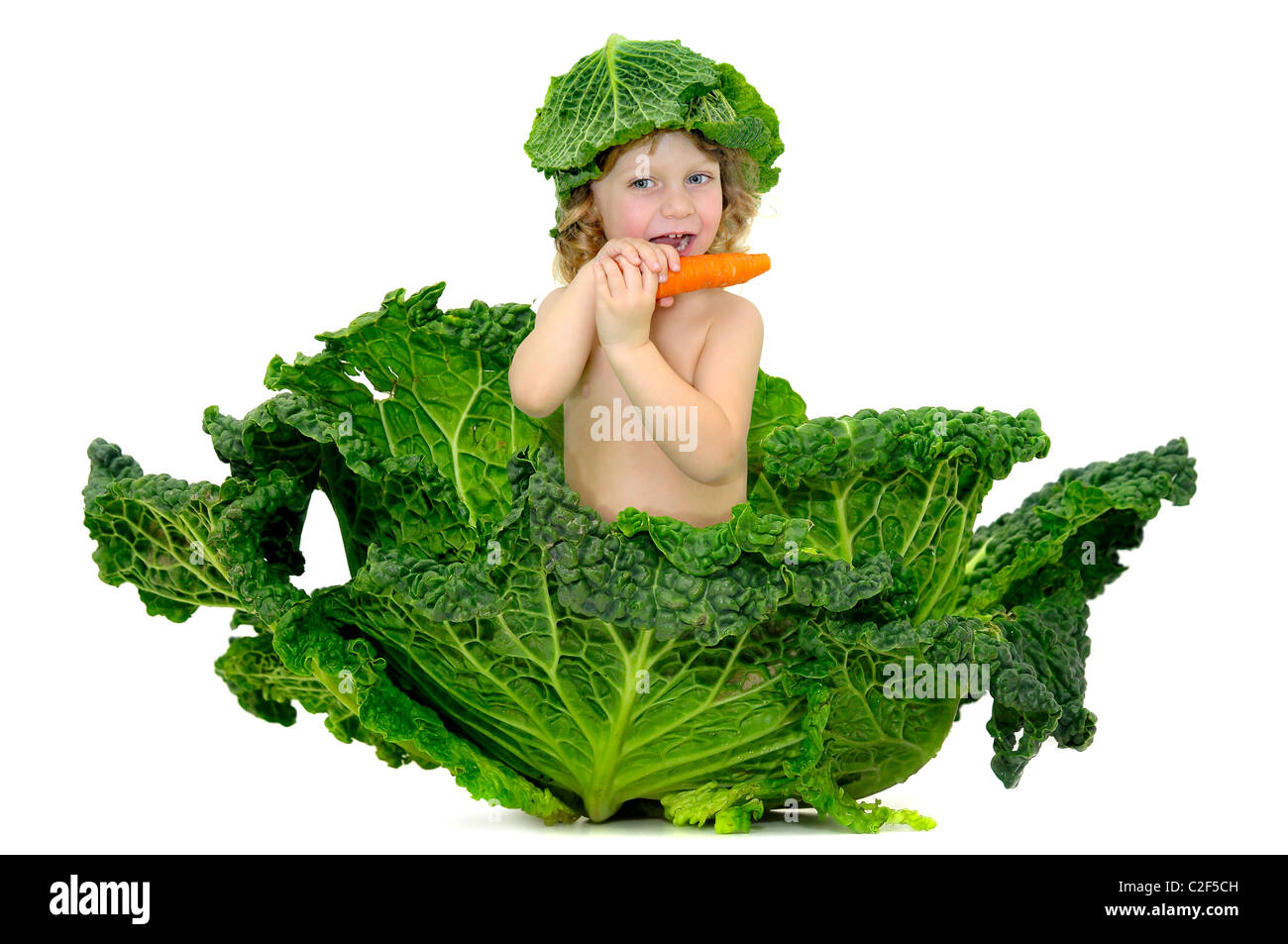 Beautiful young boy inside a cabbage eating carrots Stock Photo - Alamy