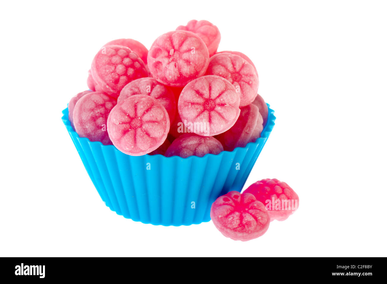 pink raspberry candy in blue cup on white background Stock Photo - Alamy