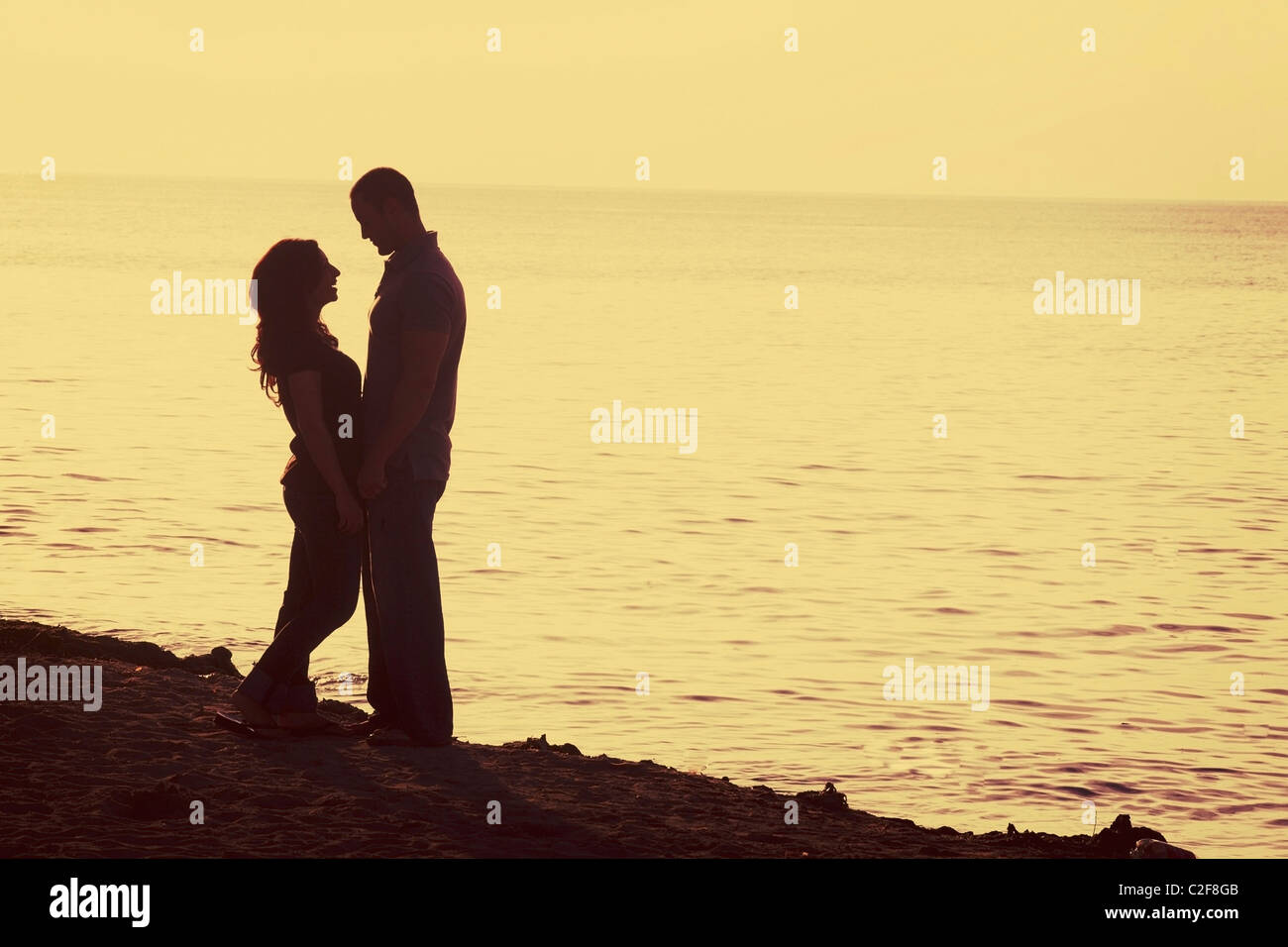 Silhouette Of A Couple Standing On The Beach Stock Photo - Alamy