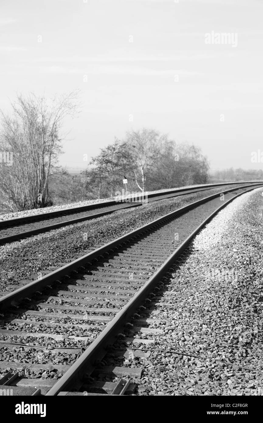 Vertical monochrome take of a bent railroad track Stock Photo - Alamy