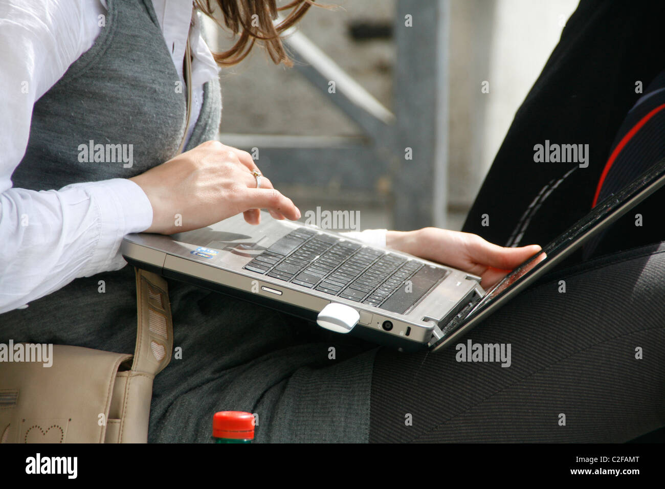 detail of young woman using laptop computer in street road in city town ...