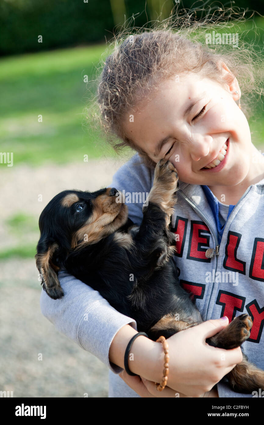 Puppy gently pushing paw to little girl's face Stock Photo - Alamy