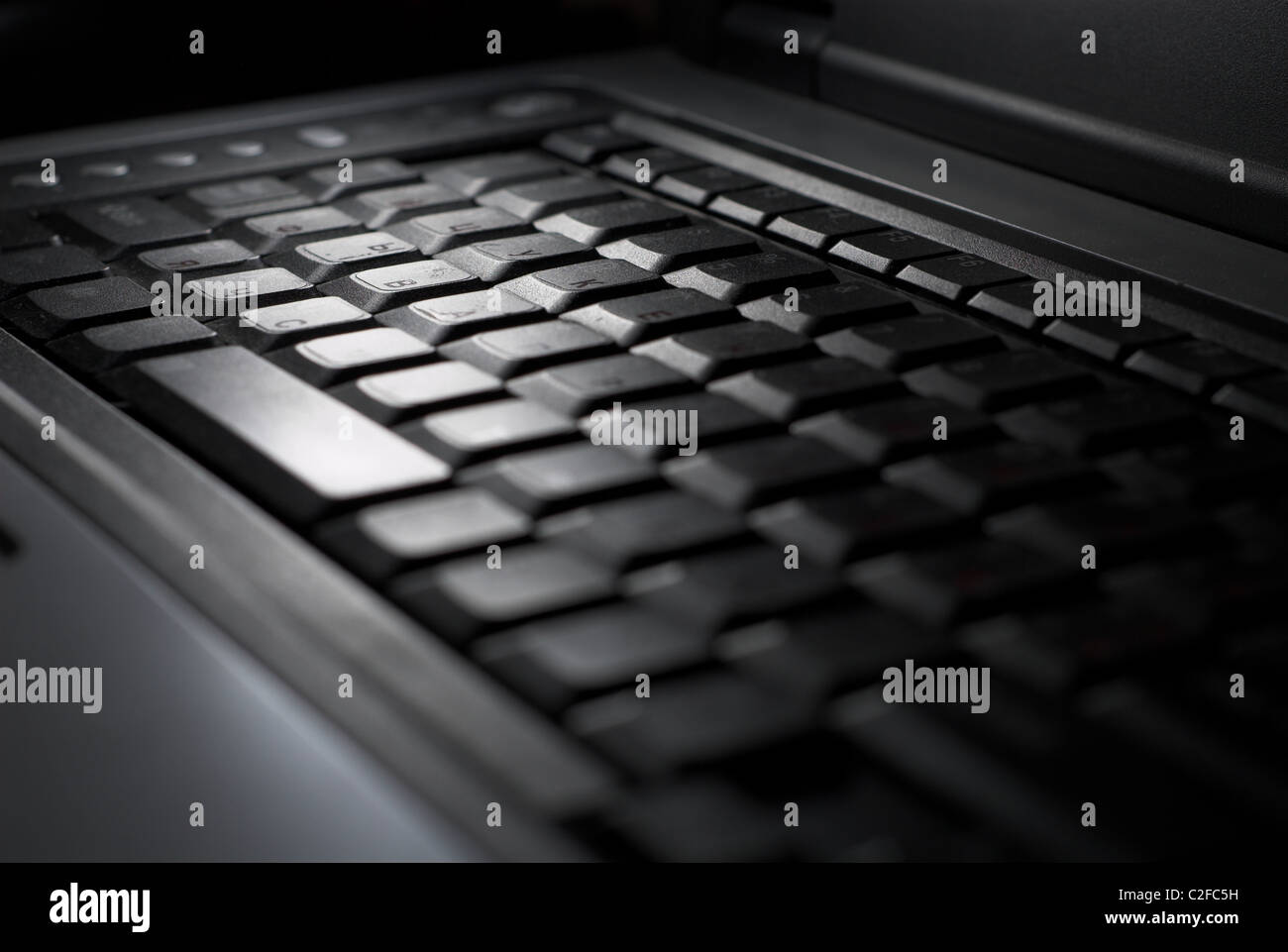 Laptop keyboard in cold colours. Flash is opposite to the camera Stock ...