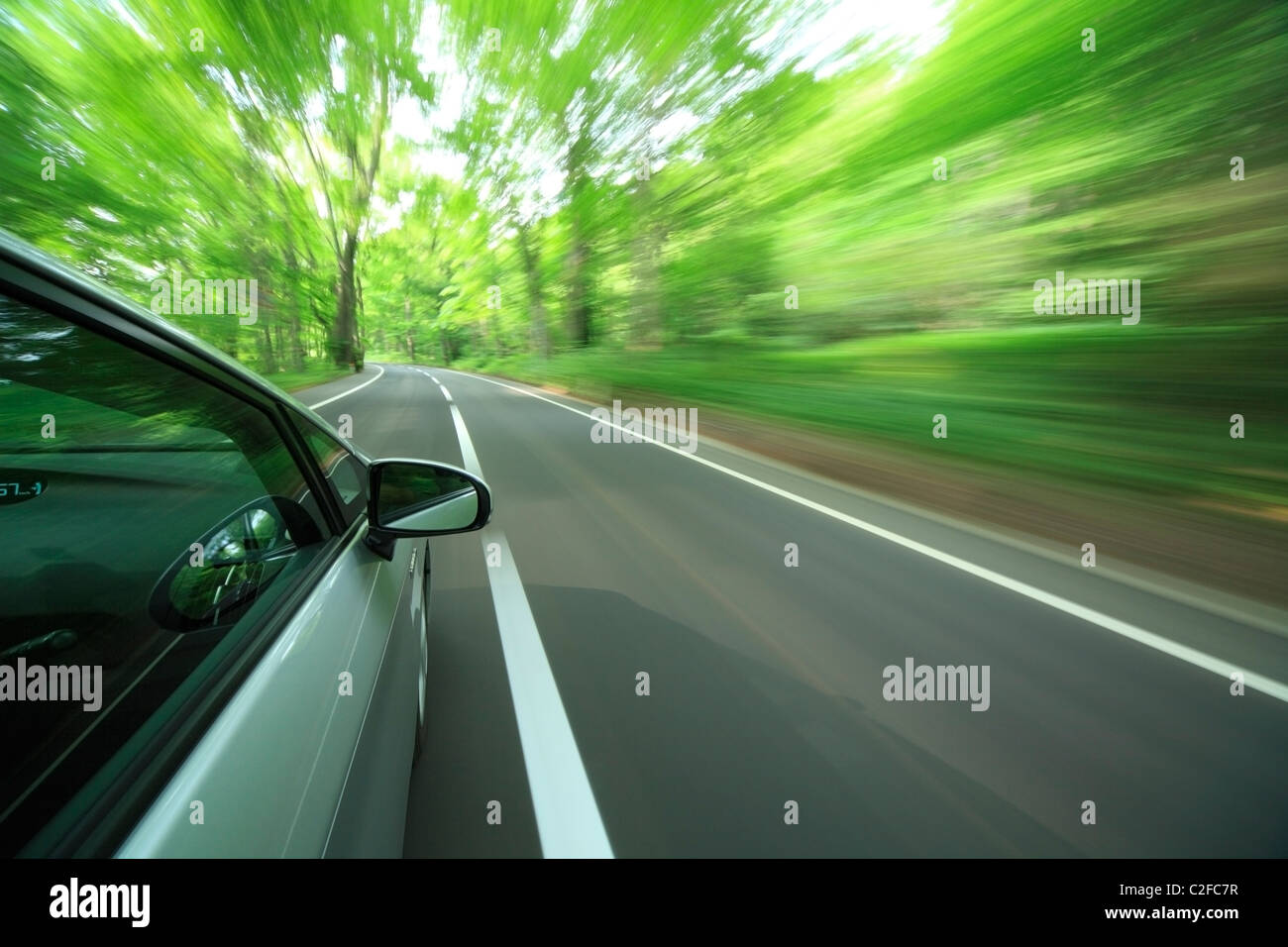 car driving fast into forest Stock Photo - Alamy