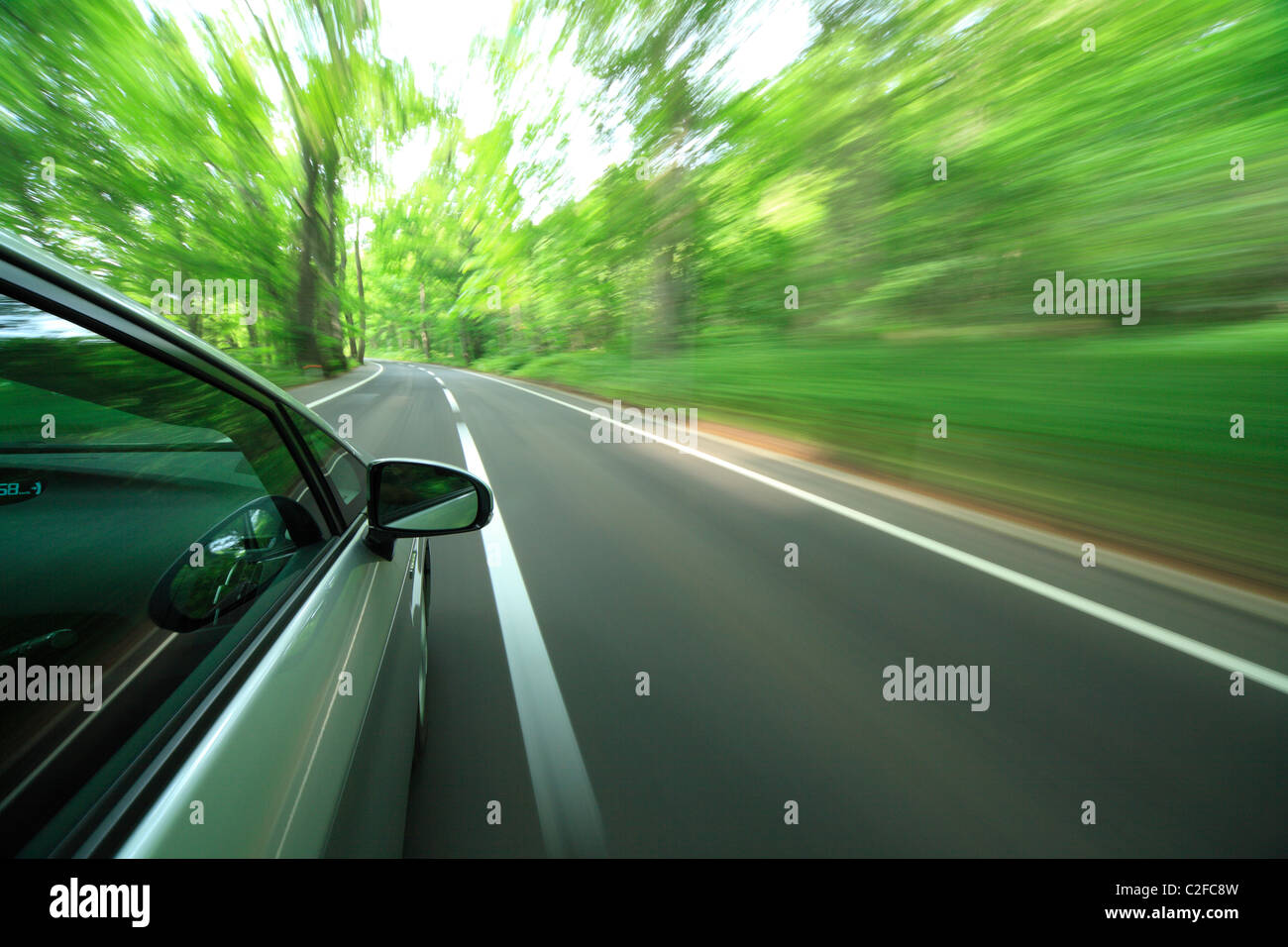 car driving fast into forest Stock Photo - Alamy