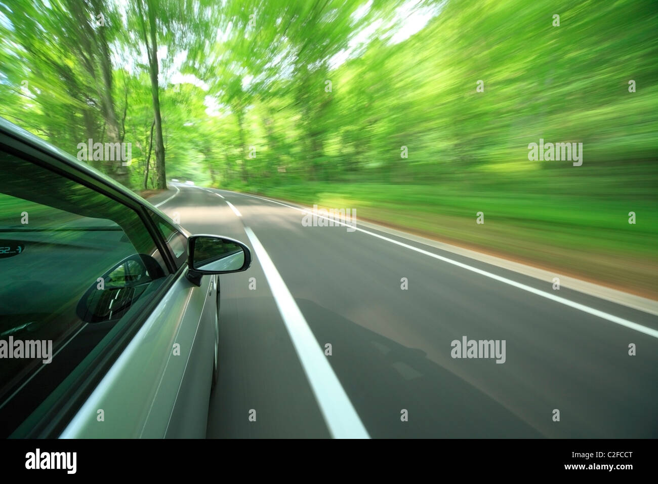 car driving fast into forest Stock Photo - Alamy