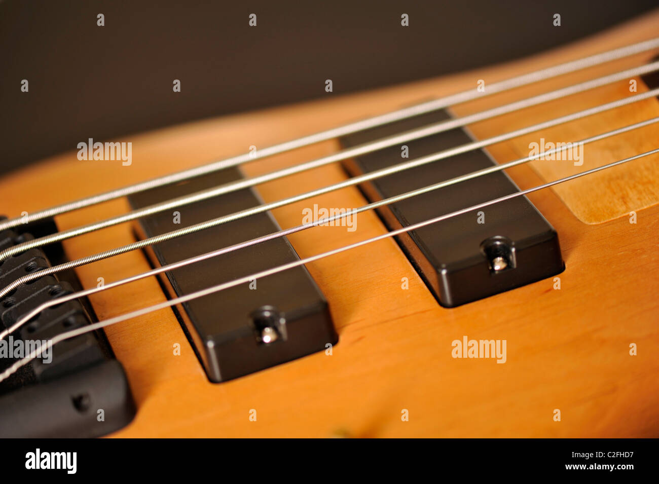 Close-up of pickups and strings of a 5-string electric bass guitar ...