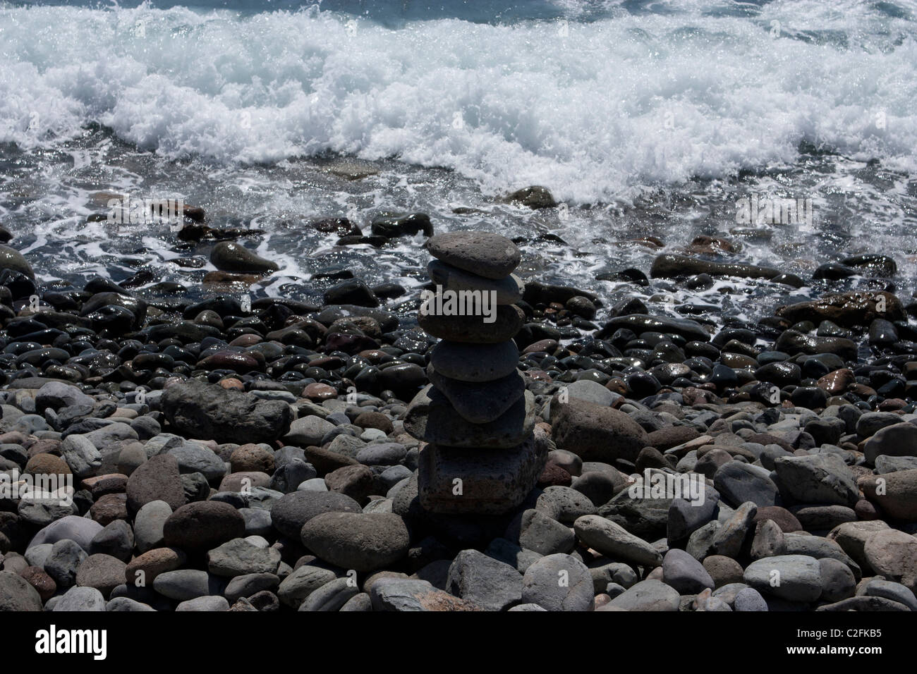 Stack of rocks with incoming tide on beach Stock Photo - Alamy