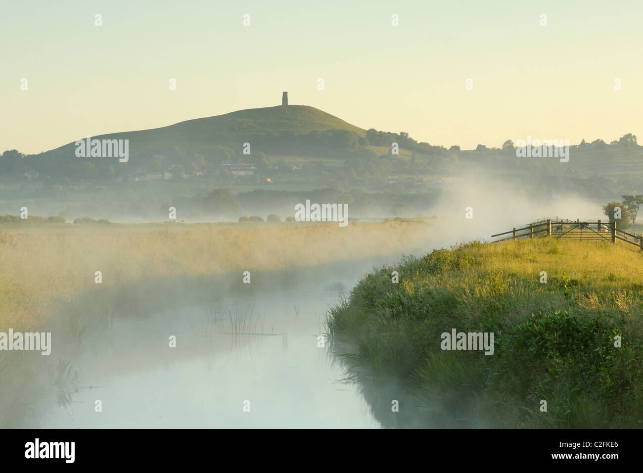 The River Brue with Glastonbury Tor in the distance during a misty ...