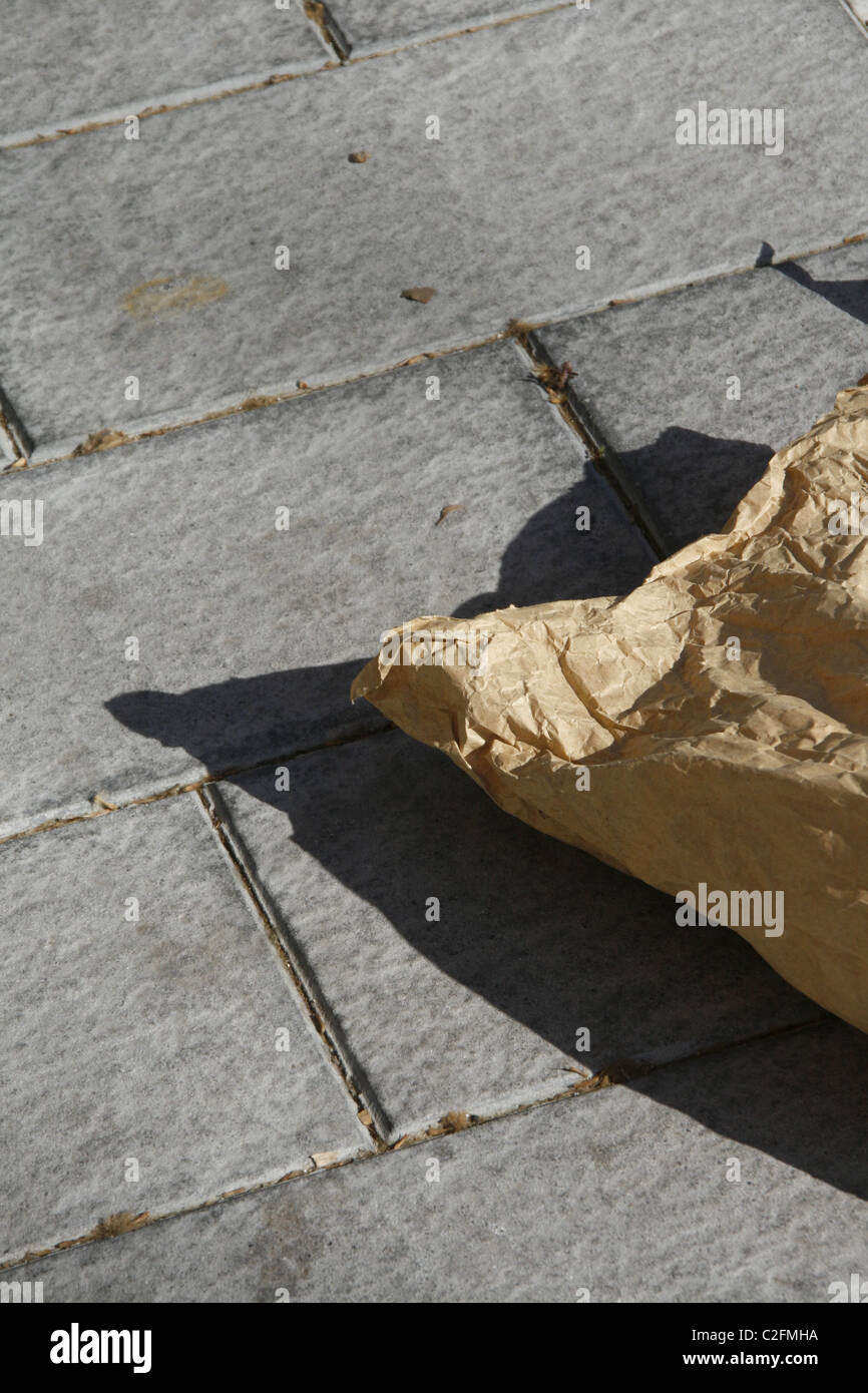 one brown paper bag litter on street road in city town Stock Photo - Alamy