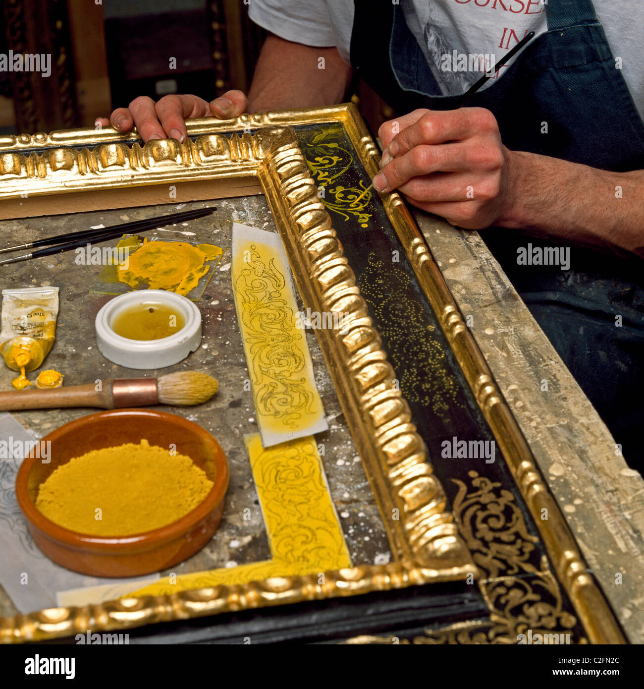Applying arabesque to a gilded frame in Arnold Wiggins workshop Stock ...