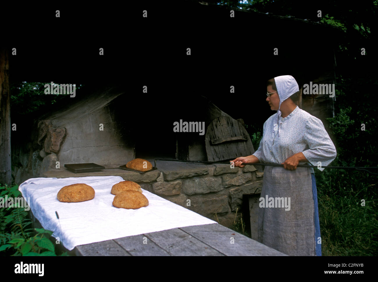1, one, Canadian woman wearing period costume, baking bread, Acadian ...