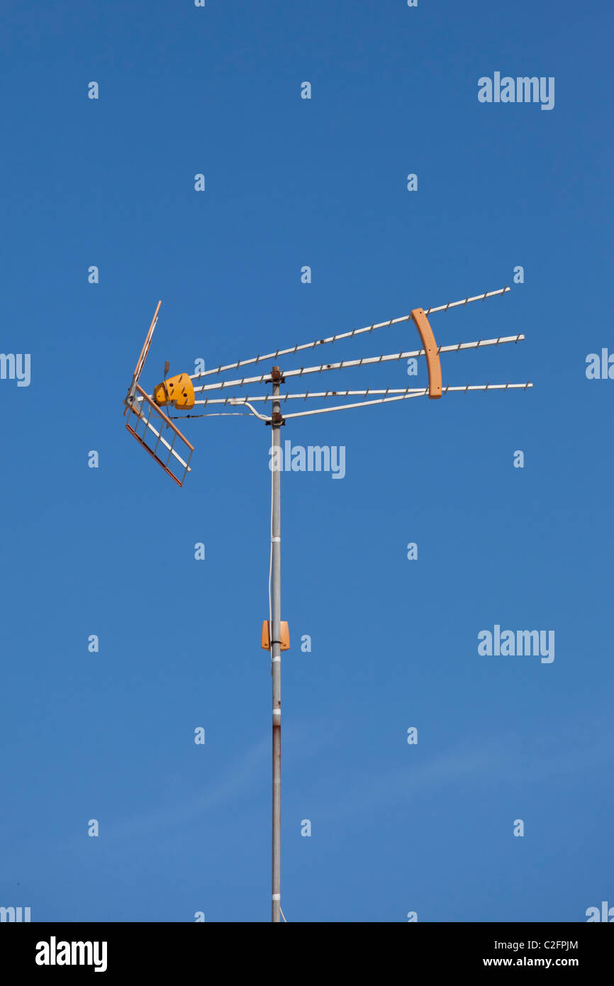 A colourful TV aerial against a blue sky Stock Photo - Alamy