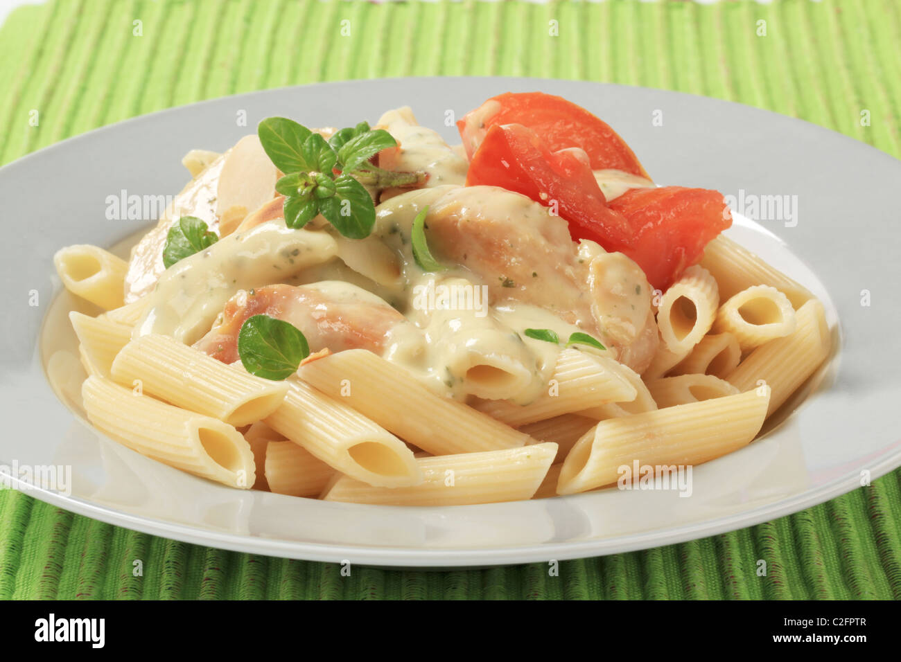 Pasta tubes, chicken meat and cream sauce Stock Photo - Alamy