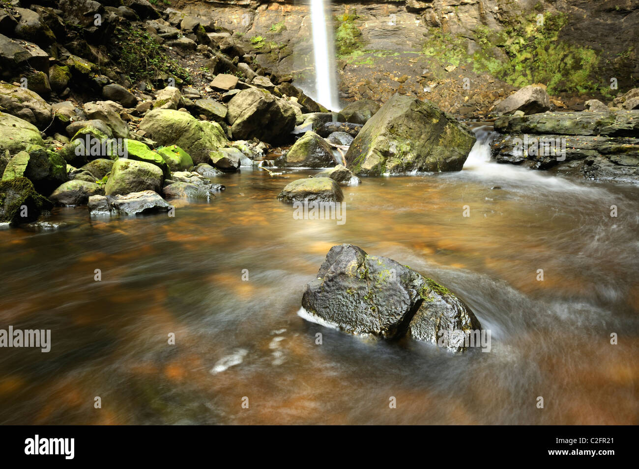 Water running through rocks at the foot of Hardraw Force, the highest ...