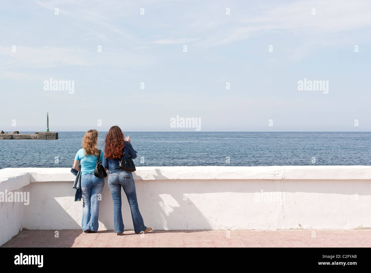Women look out over the sea on the waterfront in Kholmsk, Sakhalin ...